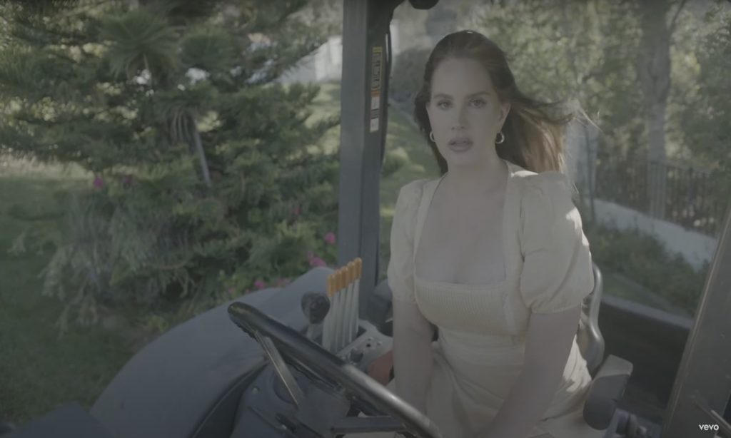 Lana Del Rey Rides A Tractor & Decorates Cakes In ‘Blue Banisters’ Video